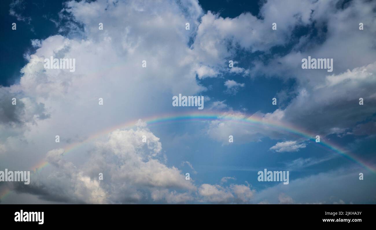 Blue sky with clouds and rainbow hi-res stock photography and images ...