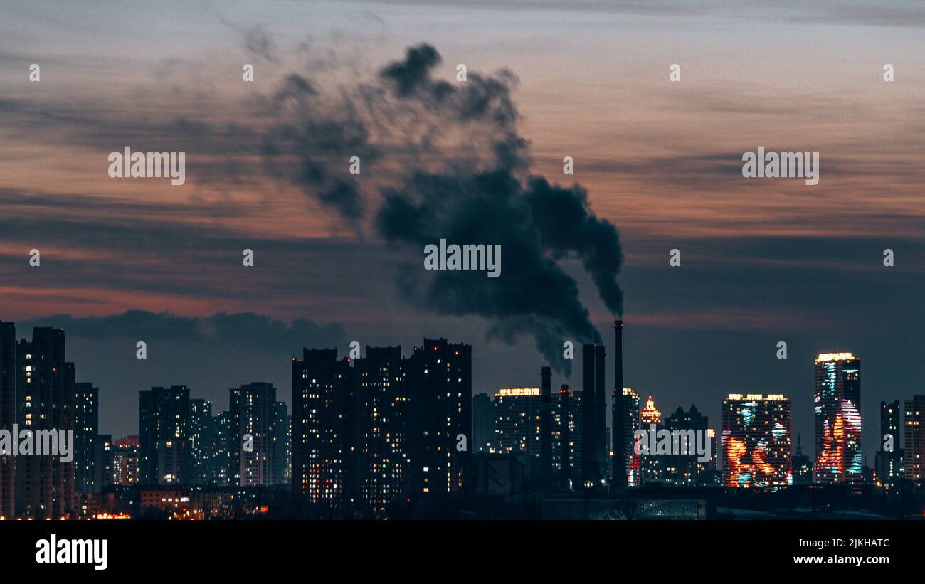 An industrial factory with smoke and modern buildings at sunset Stock ...