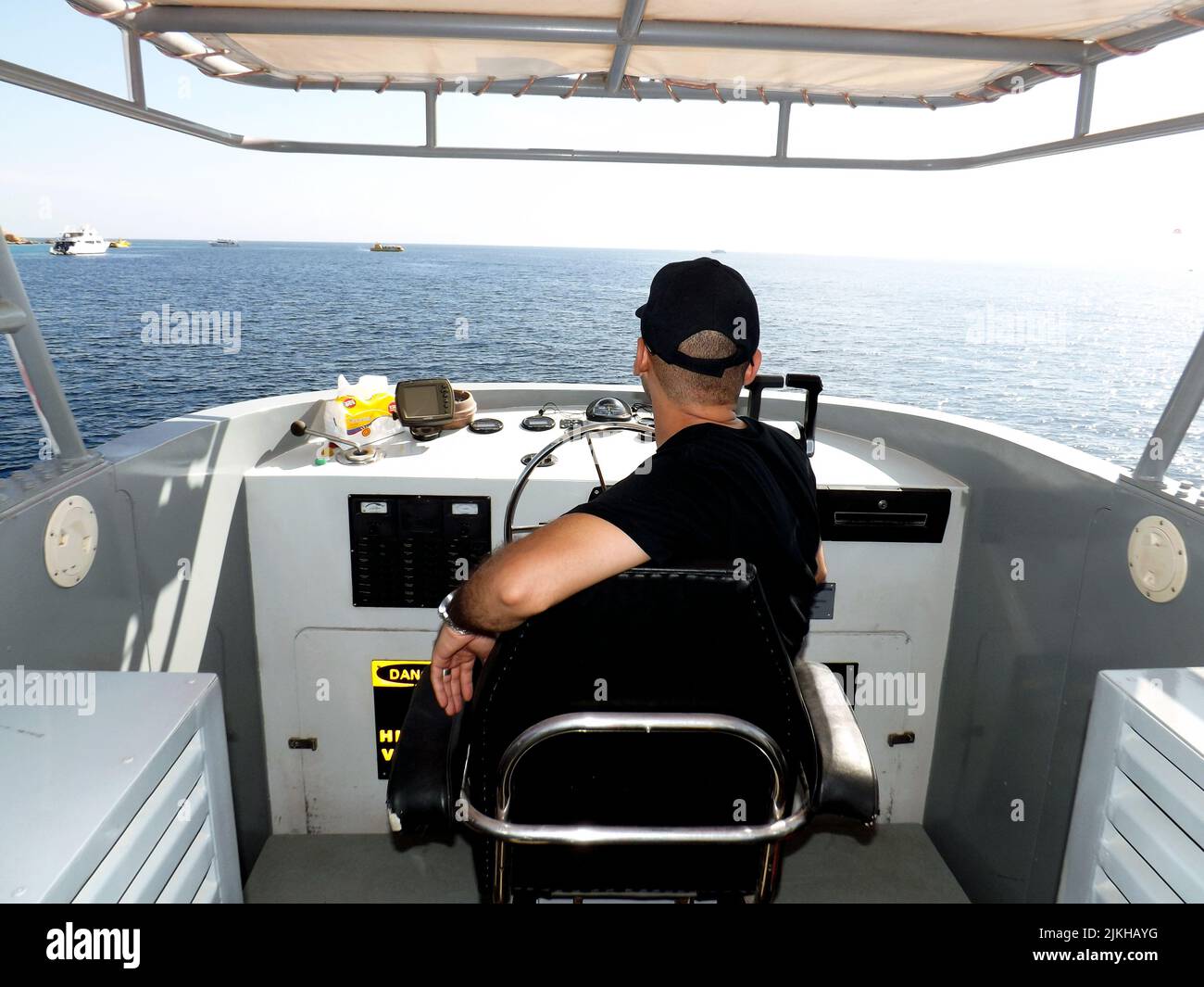 Young man steering boat hi-res stock photography and images - Alamy