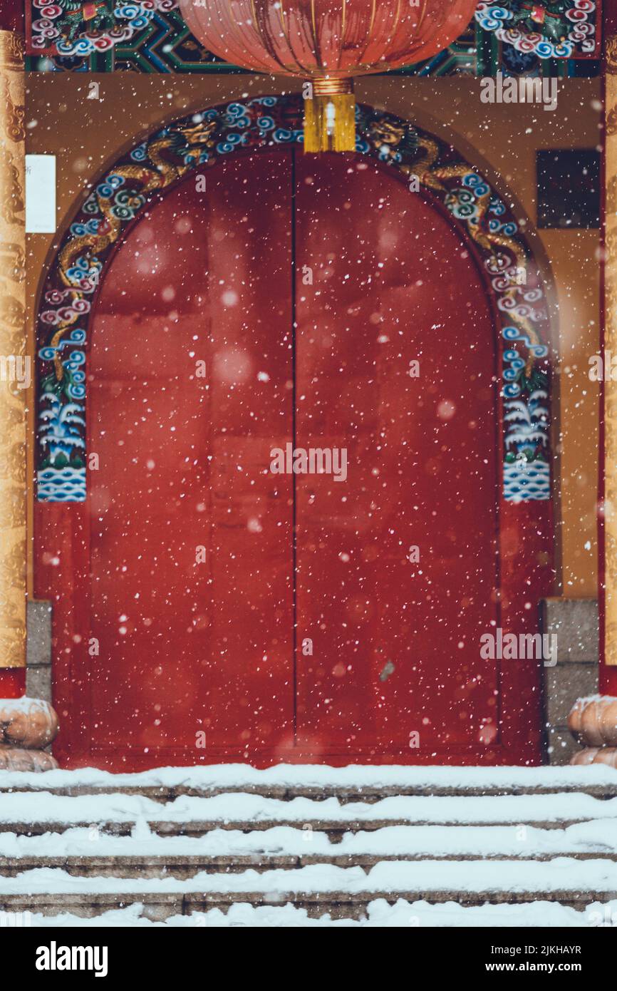 A snow coming in the foreground of an old Chinese door Stock Photo - Alamy