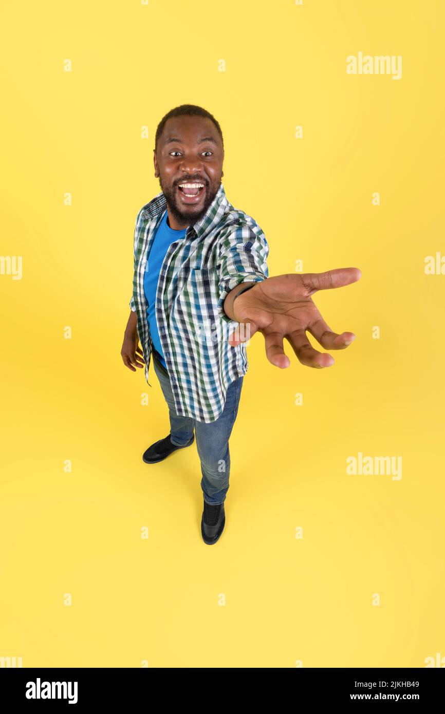 Black Guy Showing Invisible Object Shouting Stretching Hand, Yellow ...