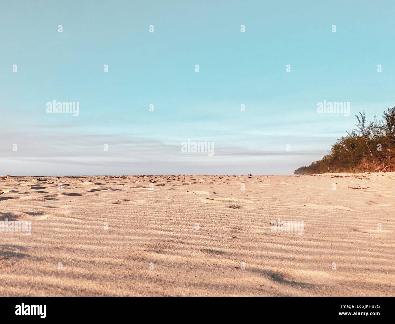 A scenic view of a sandy beach in blue sky background in daylight Stock ...