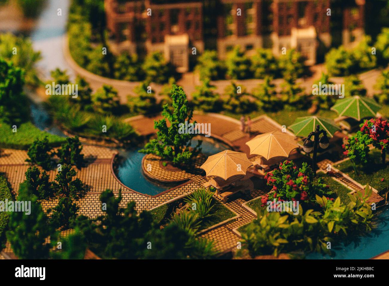 A model maquette of a green resort with trees, plants, tables and water ...
