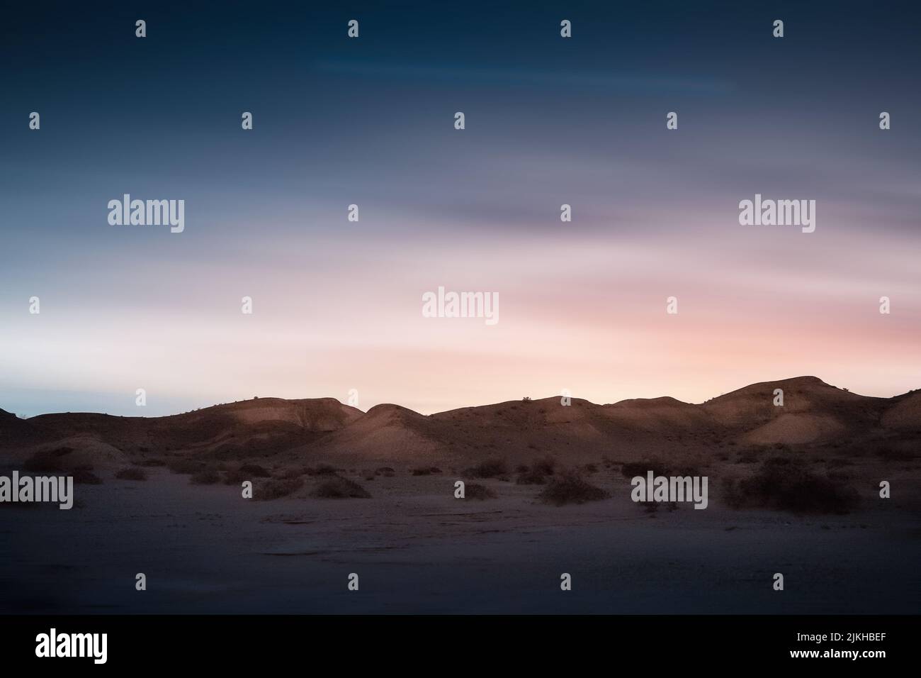 A night in the desert with the sun rising from the mountains Stock ...