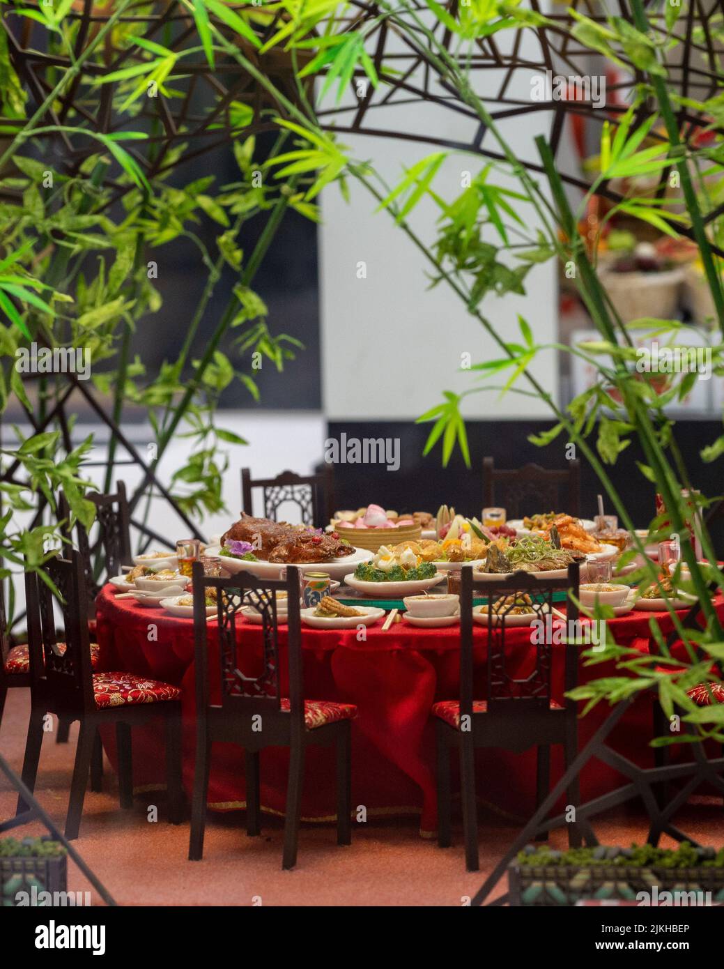 A vertical shot of a large dinner table with a gourmet dinner visible ...