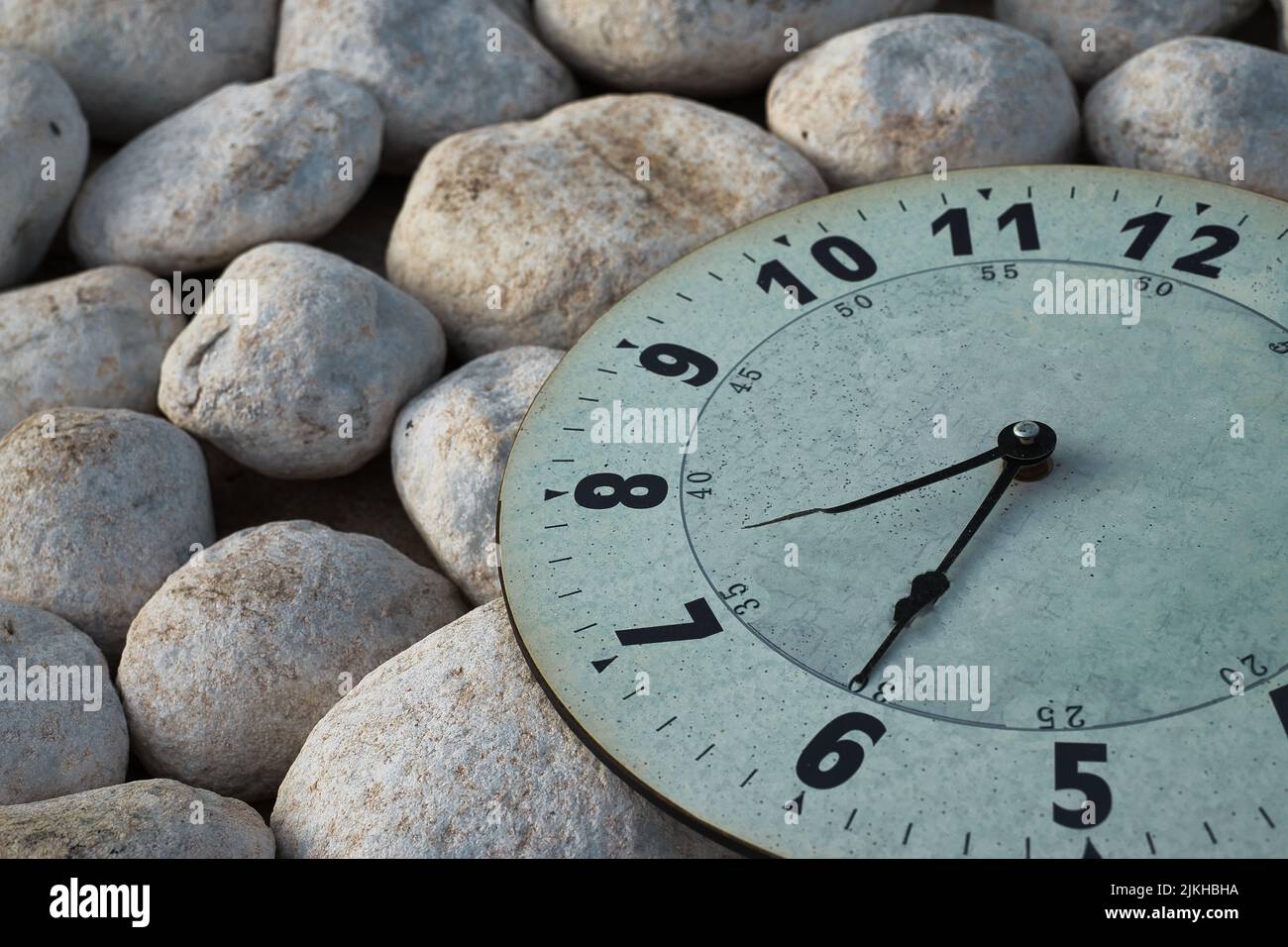 White wall clock on a background of natural stones at 6:30. Concept of ...