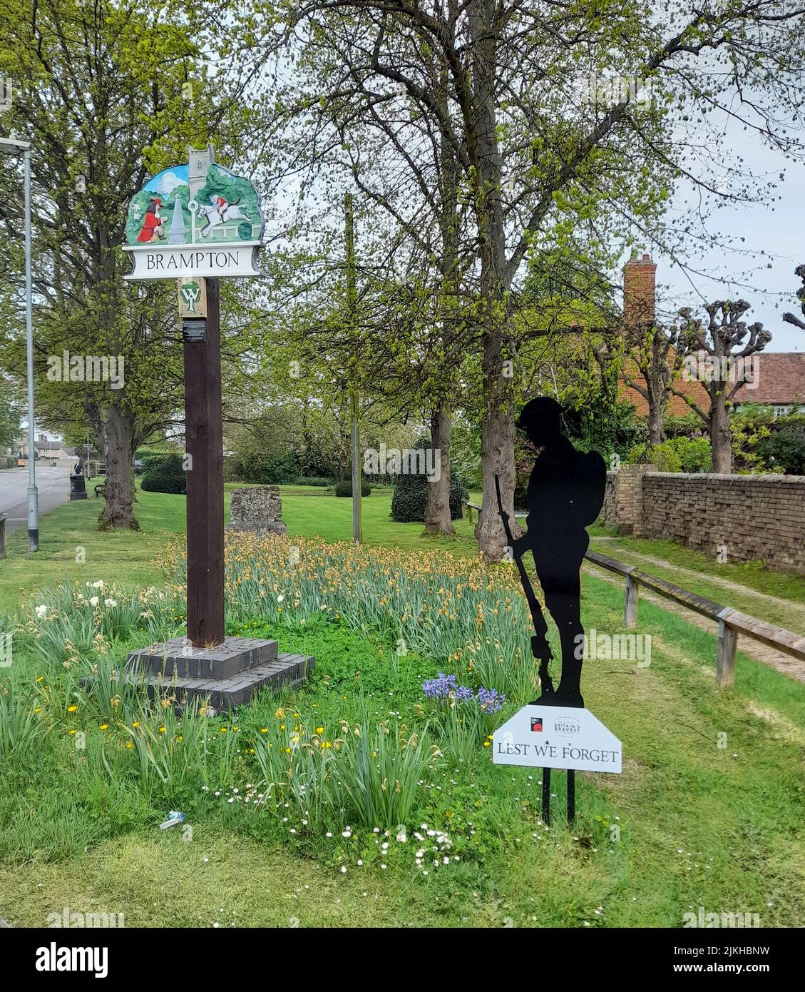A vertical shot of the village sign and war memorial in Brampton ...