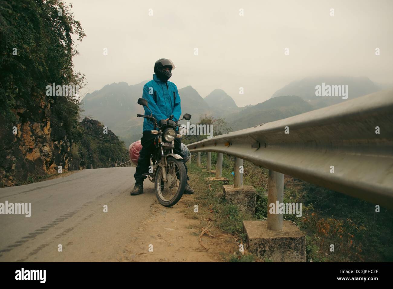 A tourist on a motorbike journey in the famous Ha giang Loop in North ...