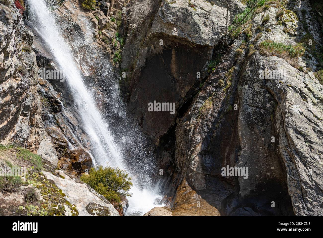 A top view of a waterfall between big rocks under the sunlight in ...