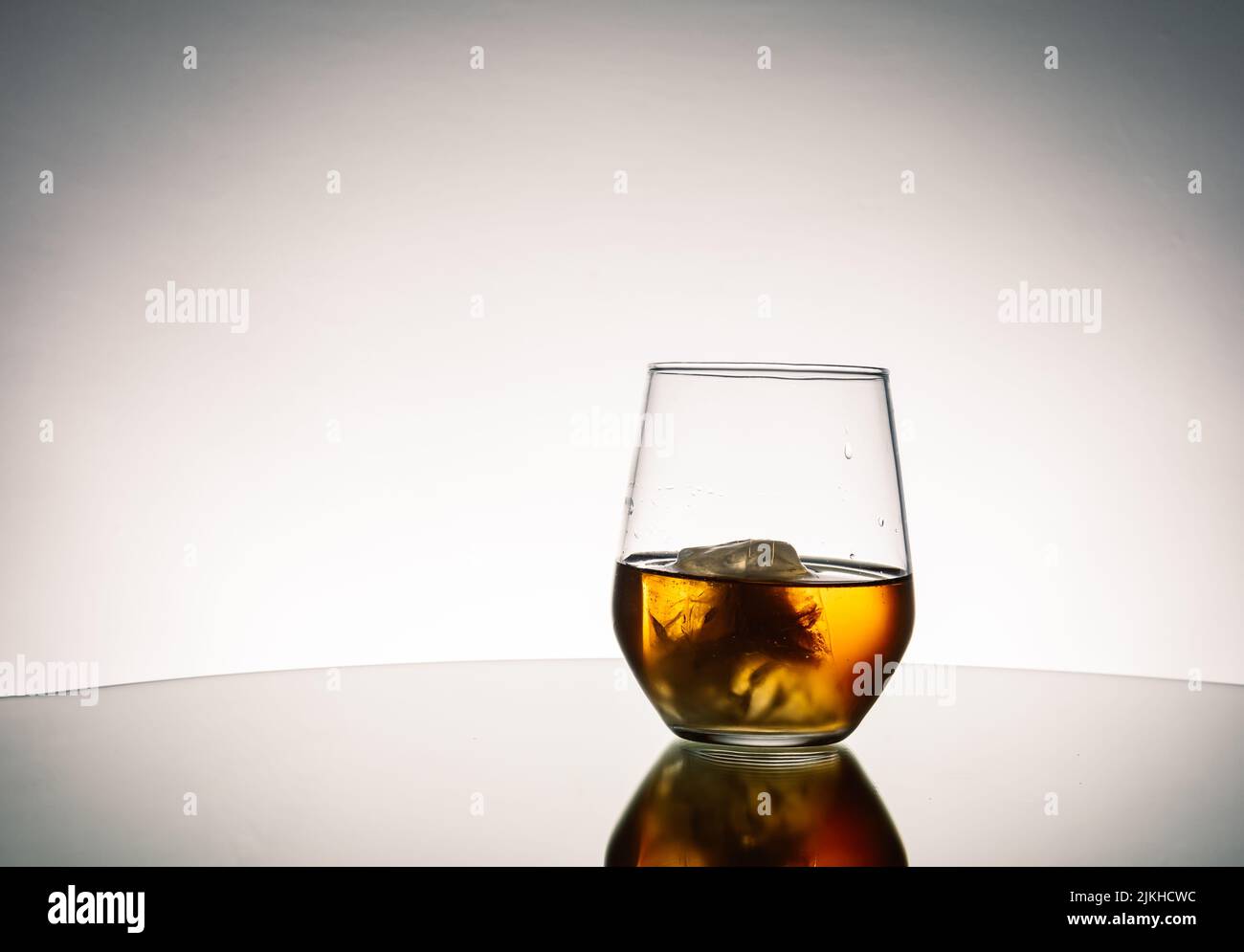 An iced Alcohol drink in a glass cup with reflection on a mirror ...