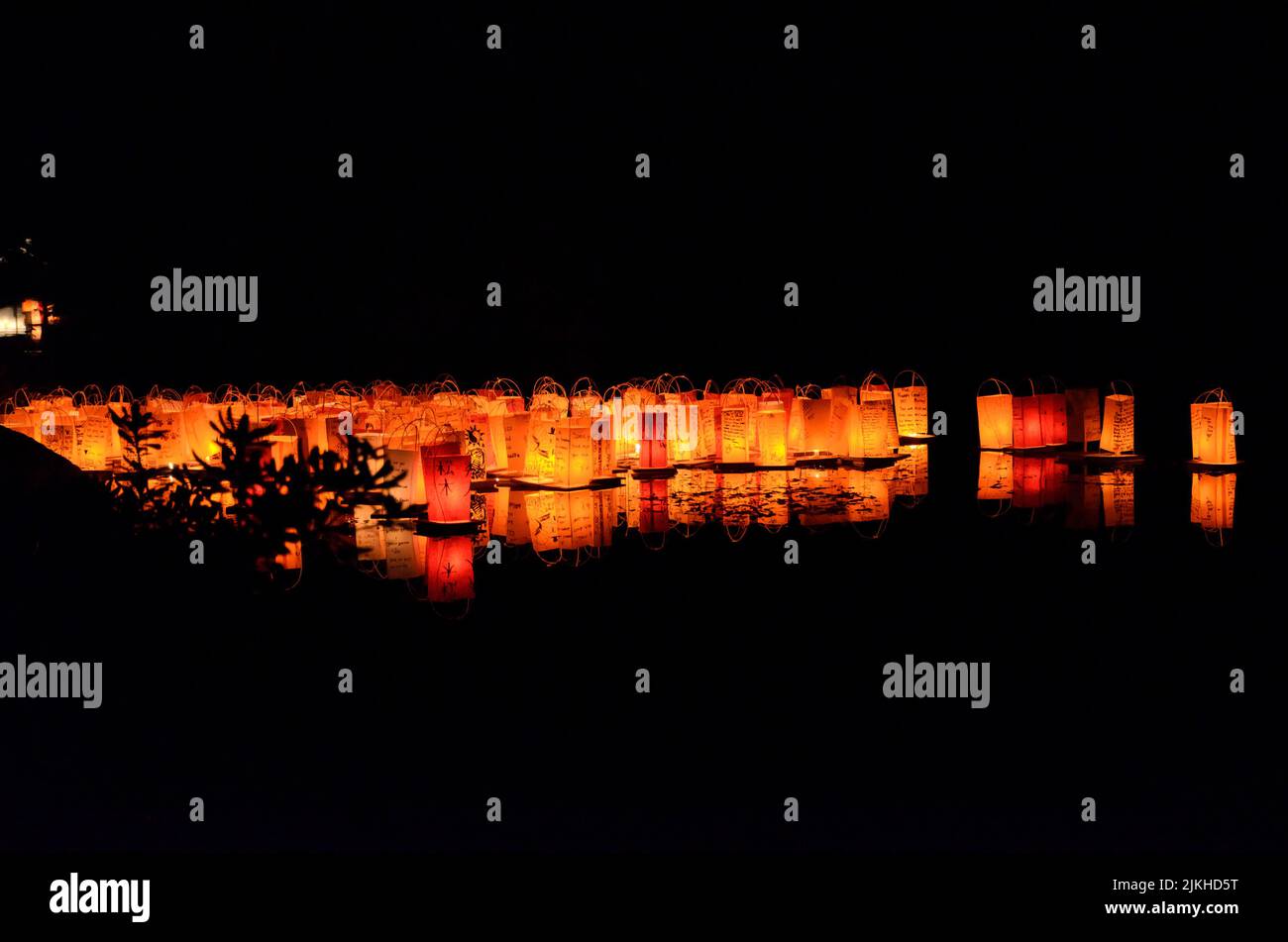 Many floating Chinese lanterns on the water in darkness Stock Photo - Alamy