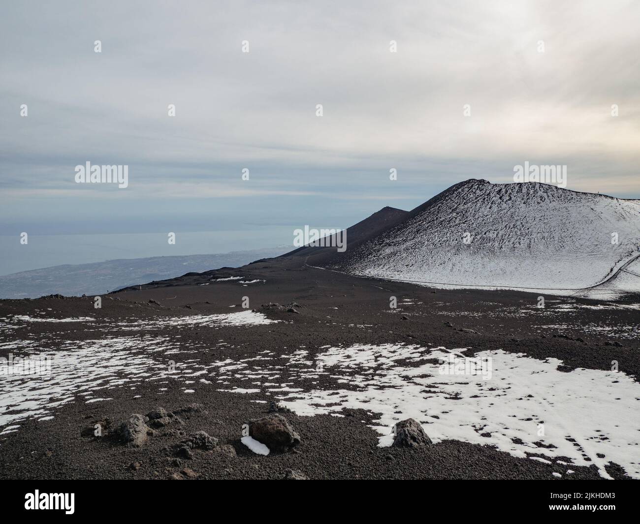 A scenic view of a mountain range partly covered with snow under a ...