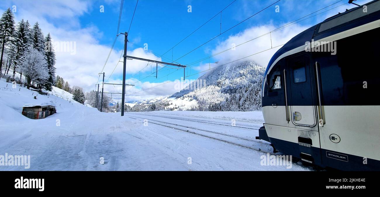 A train running through a railway in the middle of a snowy mountain ...