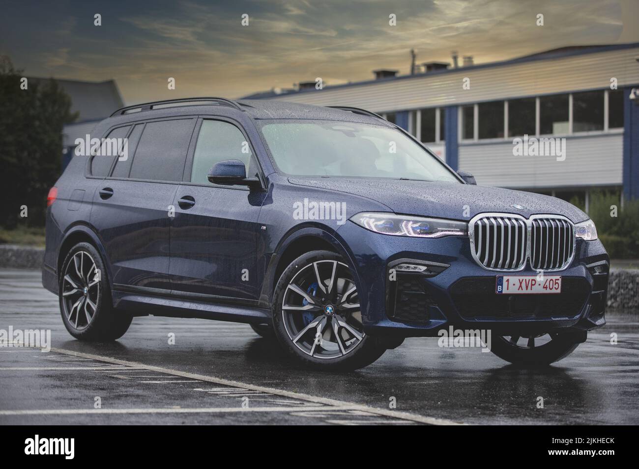 A luxury blue BMW X7 parked on the road on at cold rainy sunset Stock ...