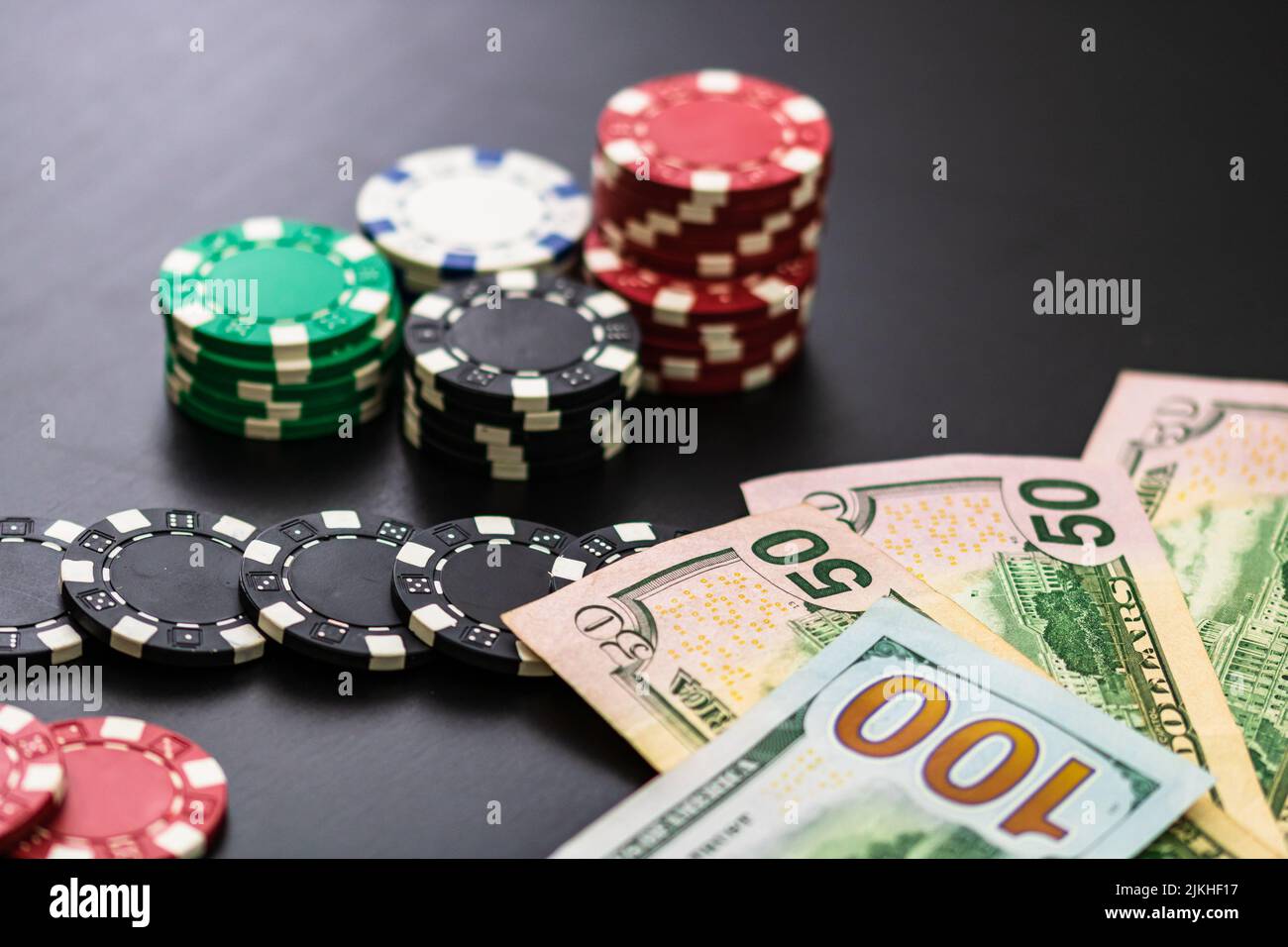 Stacks of poker chips and dollar bills on black background. Poker ...