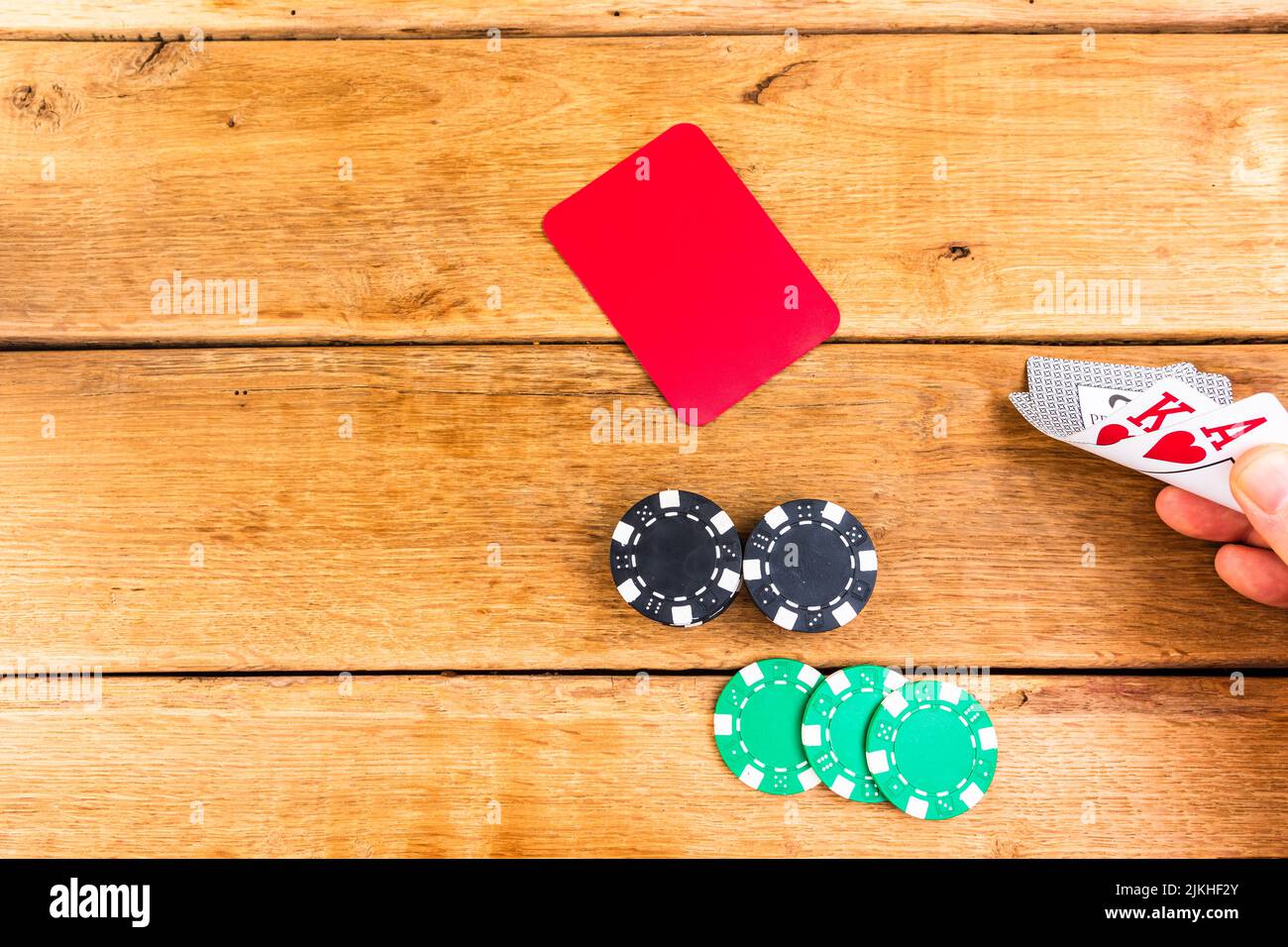 Hand having Ace and King on wooden background, poker chips, dealer ...