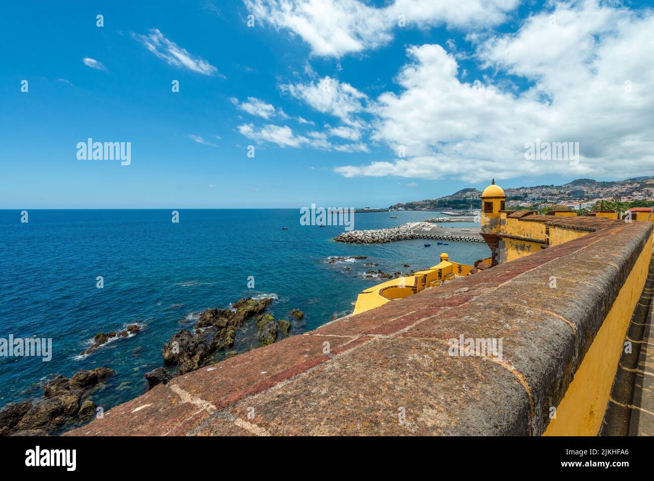 The fence of Sao Tiago castle with sea view and cloudy sky in Funchal ...