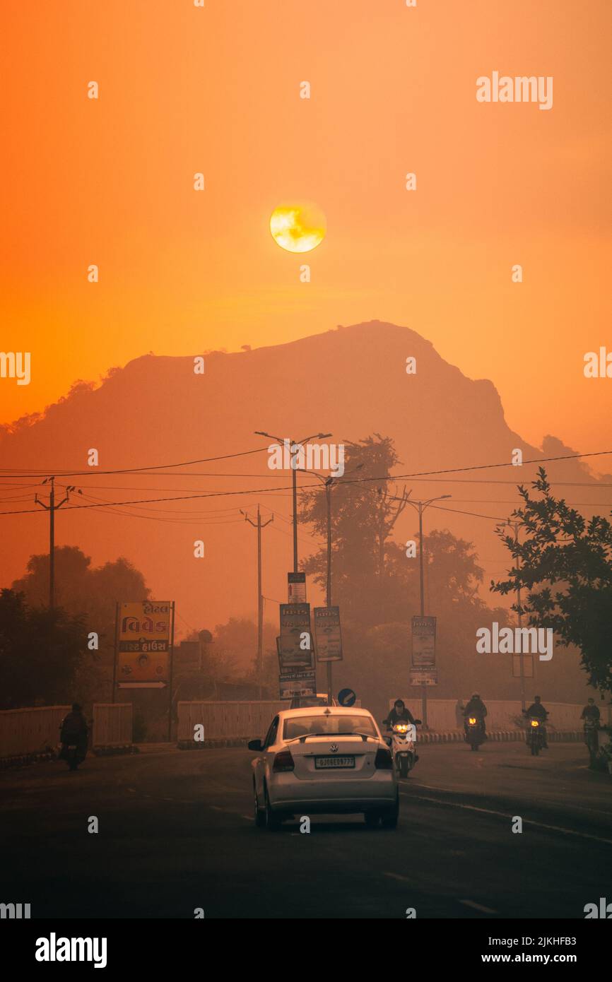A vertical shot of sun rising over the mountain on cold winter morning ...