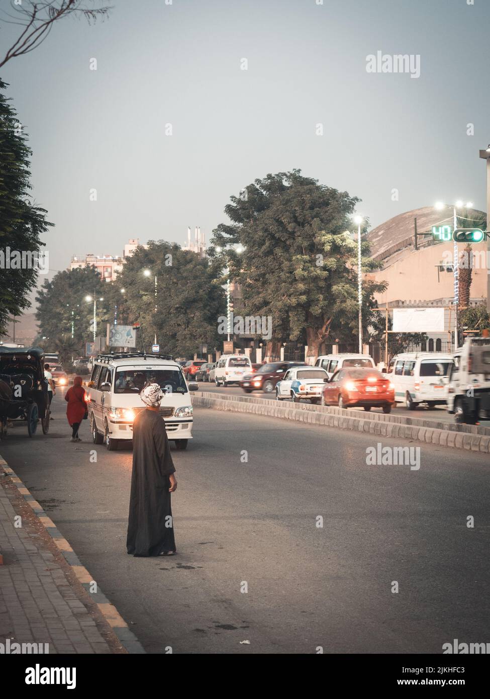 A view of a man on a street and traffic road with cars in Egypt, Aswan ...