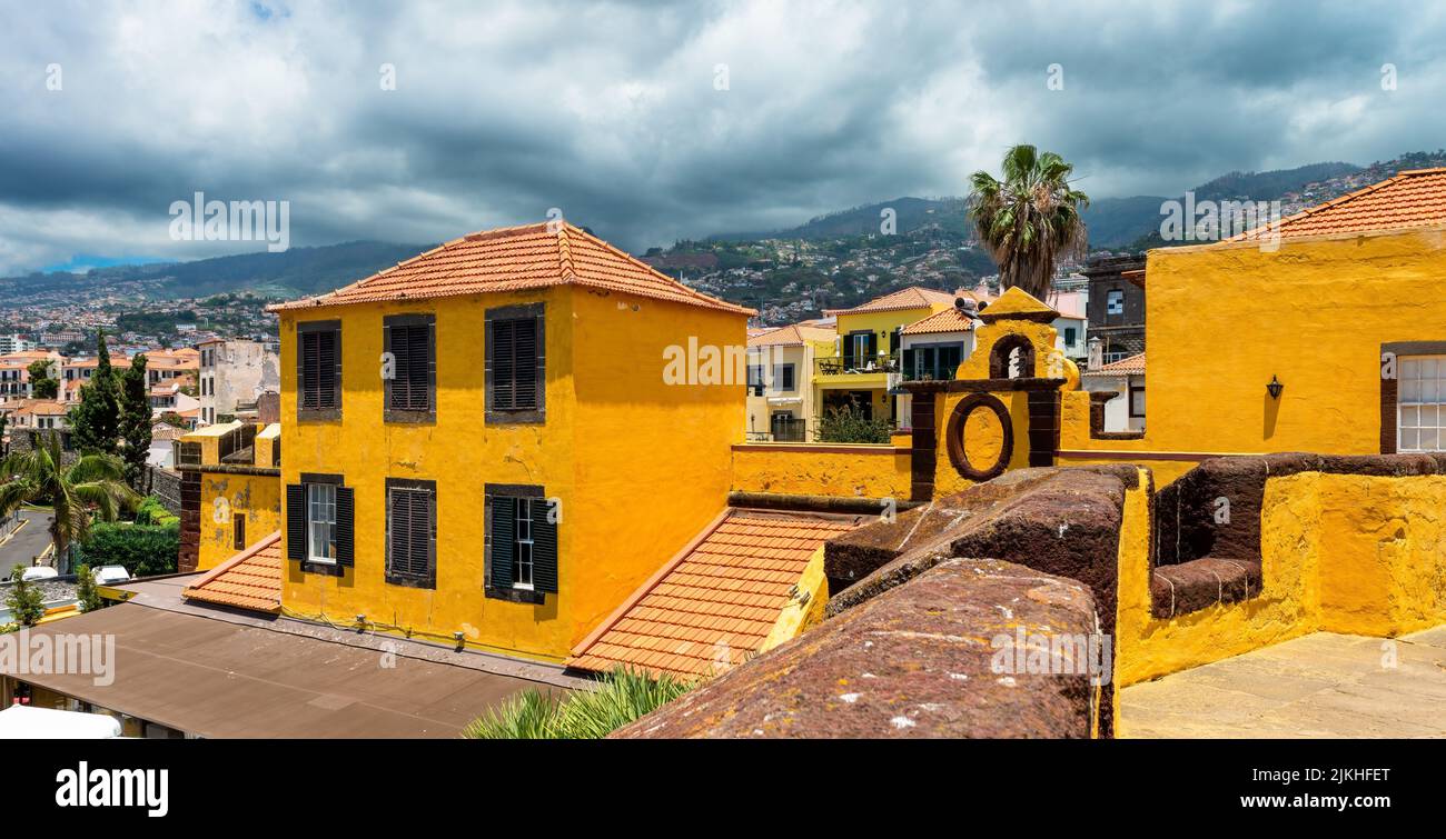 The exterior design of the Yellow castle of Sao Tiago with mountain and ...
