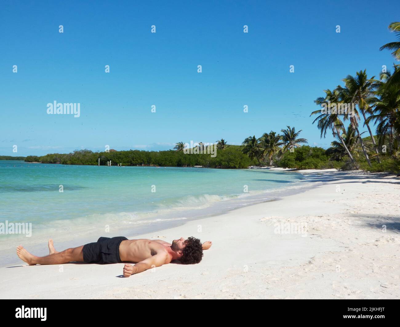lonely man lying on a paradisiacal beach very relaxed Stock Photo - Alamy