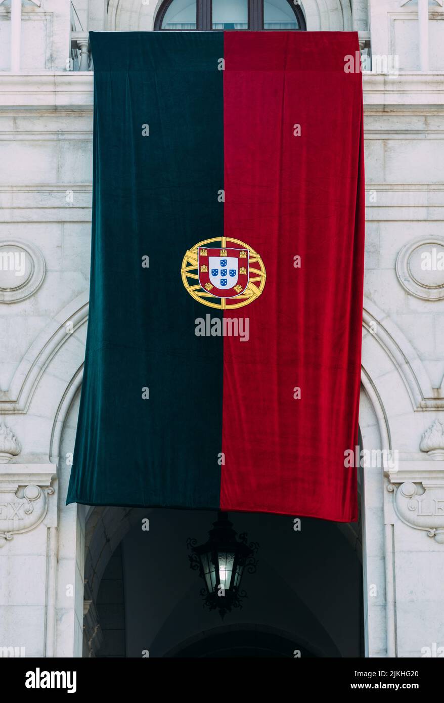The close-up of the national flag of Portugal hanging from a building ...