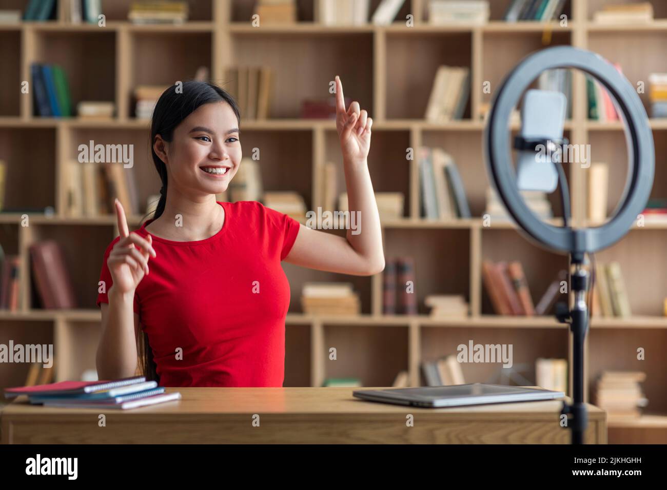 Cheerful teenager japanese female blogger shooting vlog, raises her ...