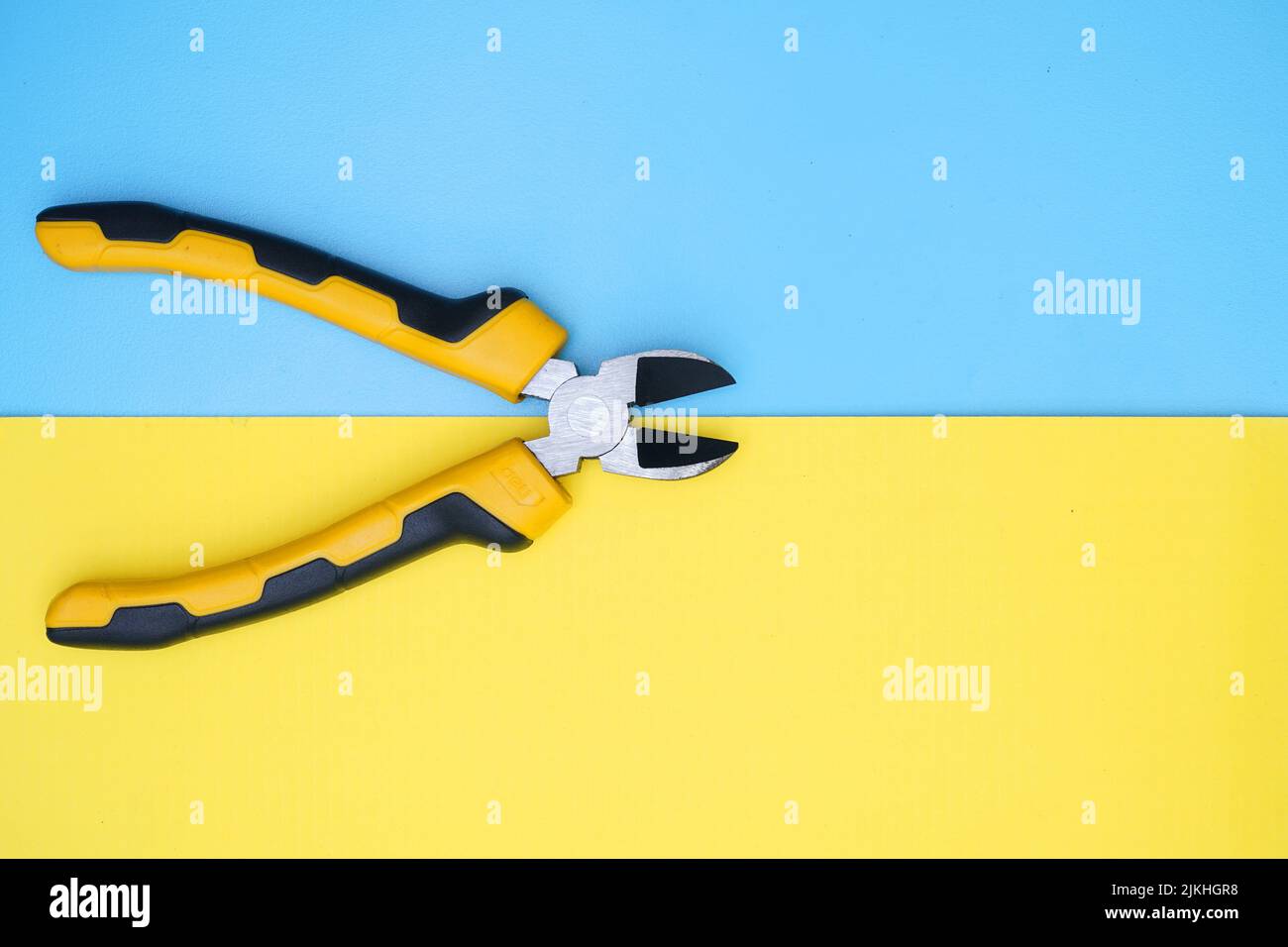 The side cutters isolated on blue-yellow background with copy space ...