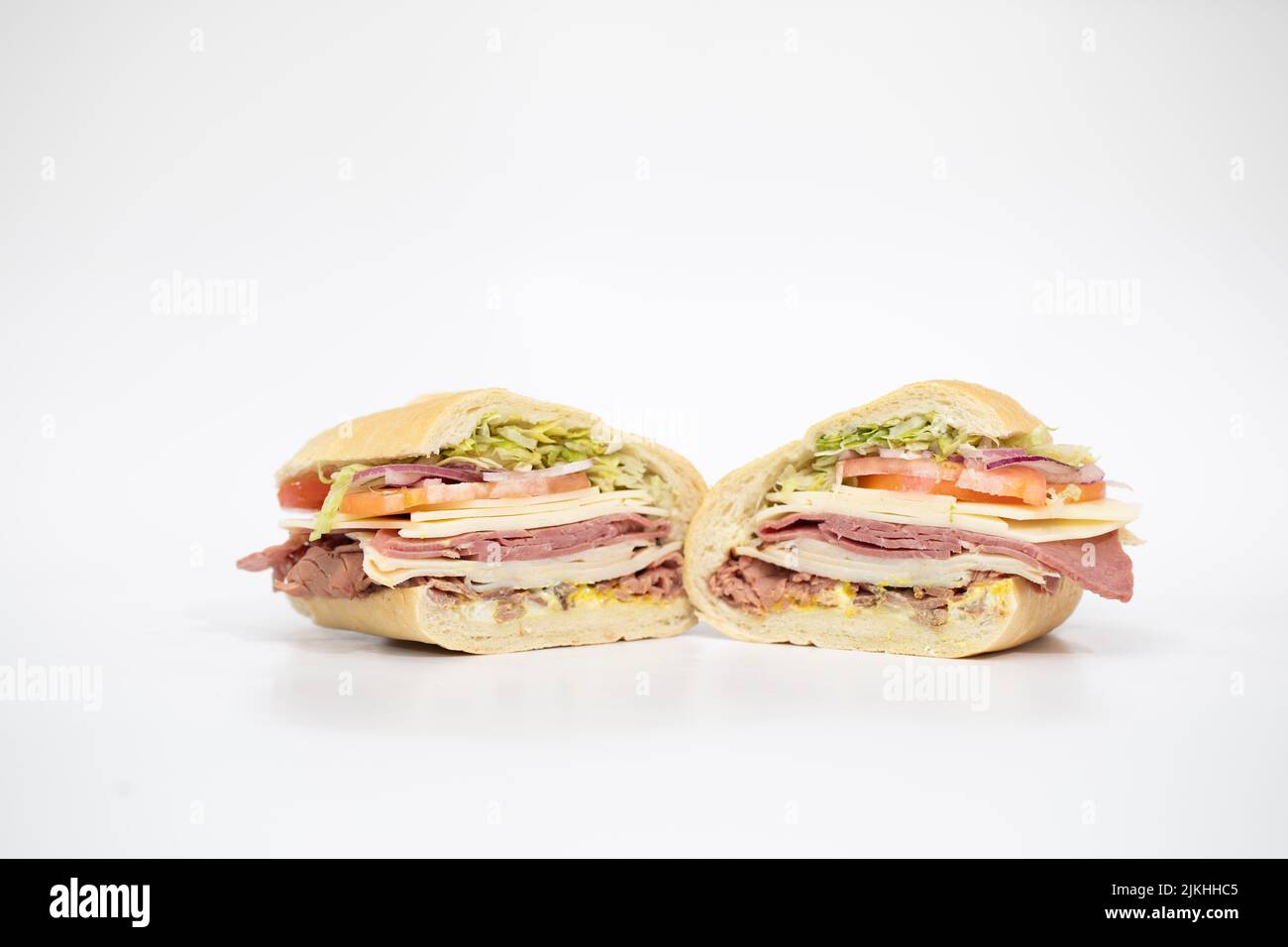An Italian sub sandwich sliced in half portraying all of its ...