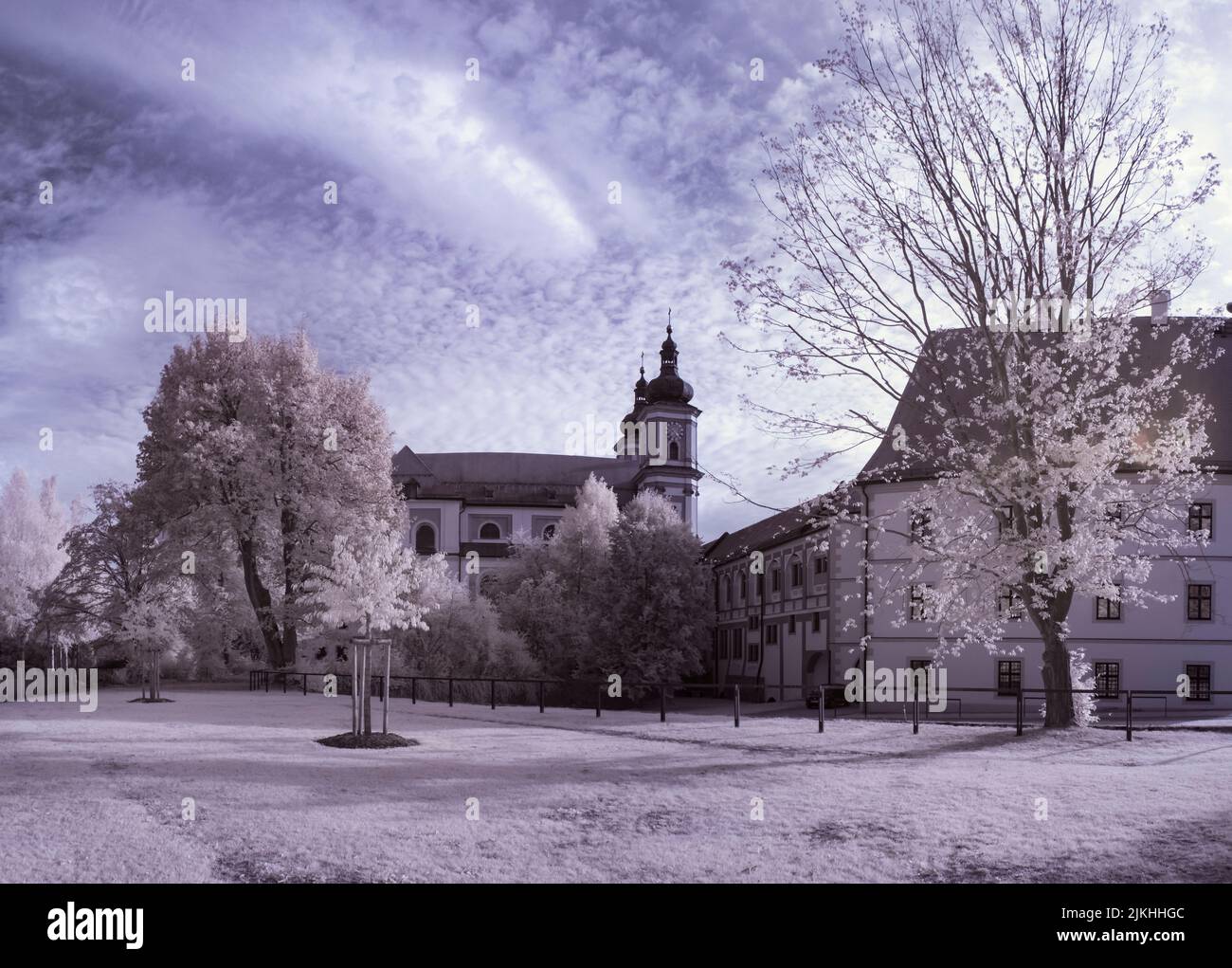 A view of a black and white church-like building with trees in front of ...