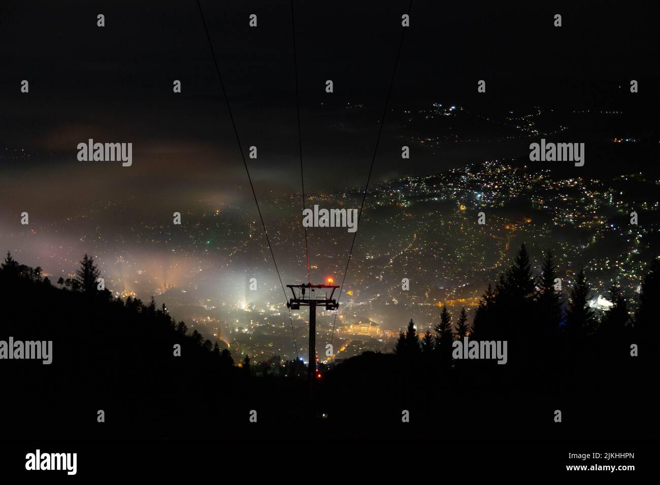 An aerial view of a ropeway with the city in the background full of ...