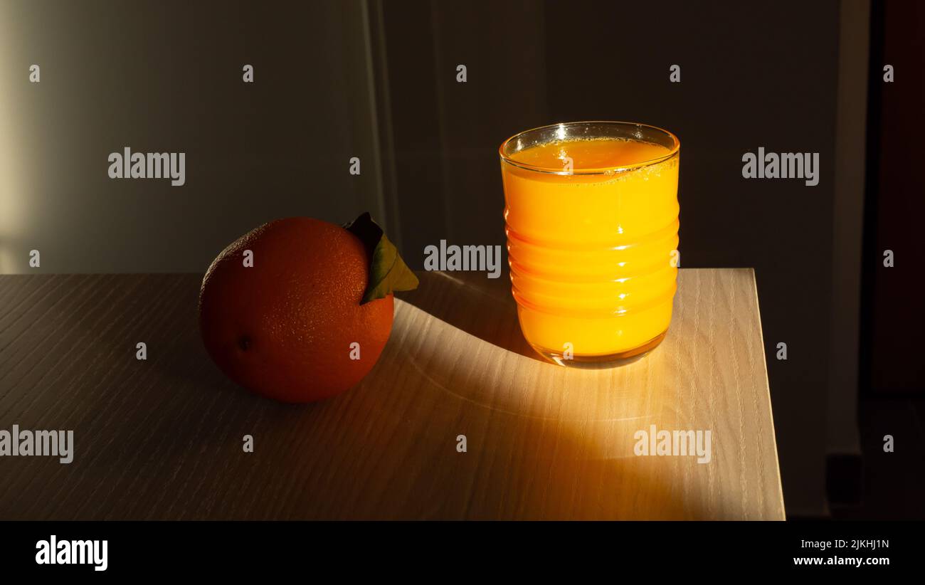 a glass of freshly squeezed juice, standing on the table and ...
