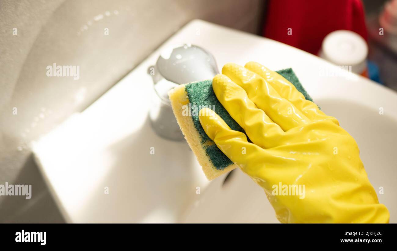 Clean up your house. Woman doing chores in bathroom, hands in yellow ...