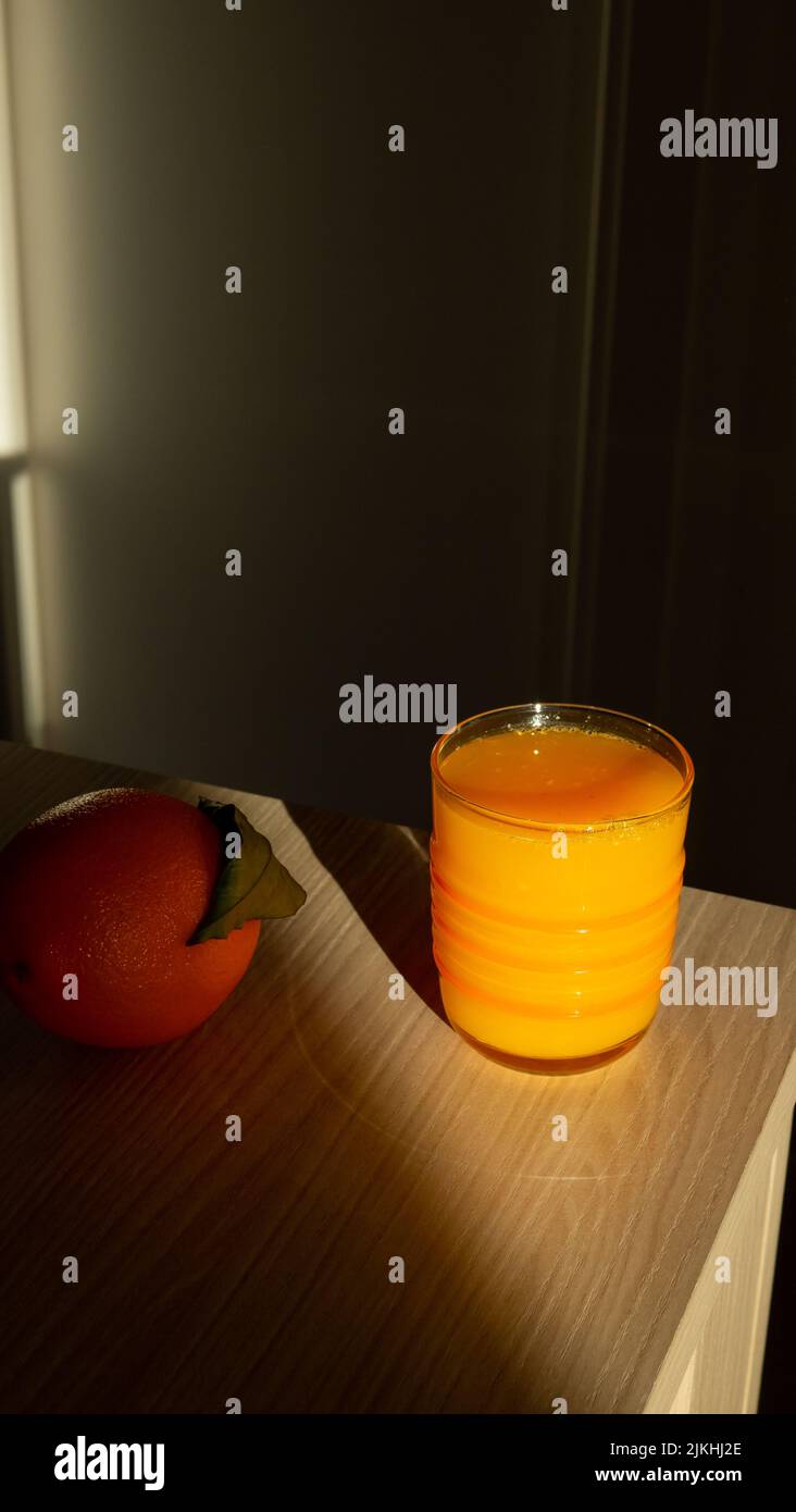 a glass of freshly squeezed juice, standing on the table and ...