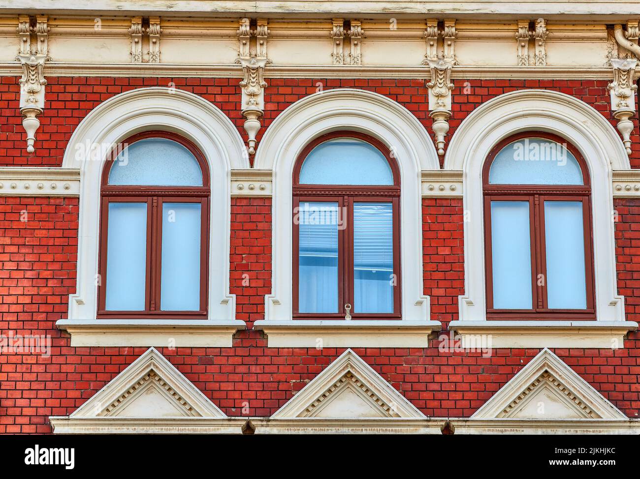 A red brick building facade with arched windows Stock Photo - Alamy