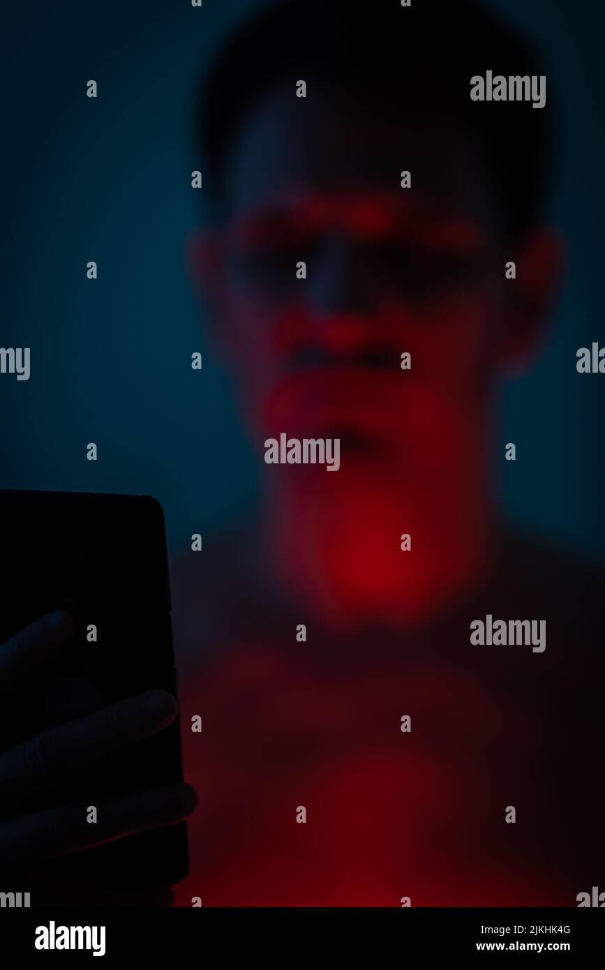 A vertical blurred portrait of a male under neon red blue lights Stock ...