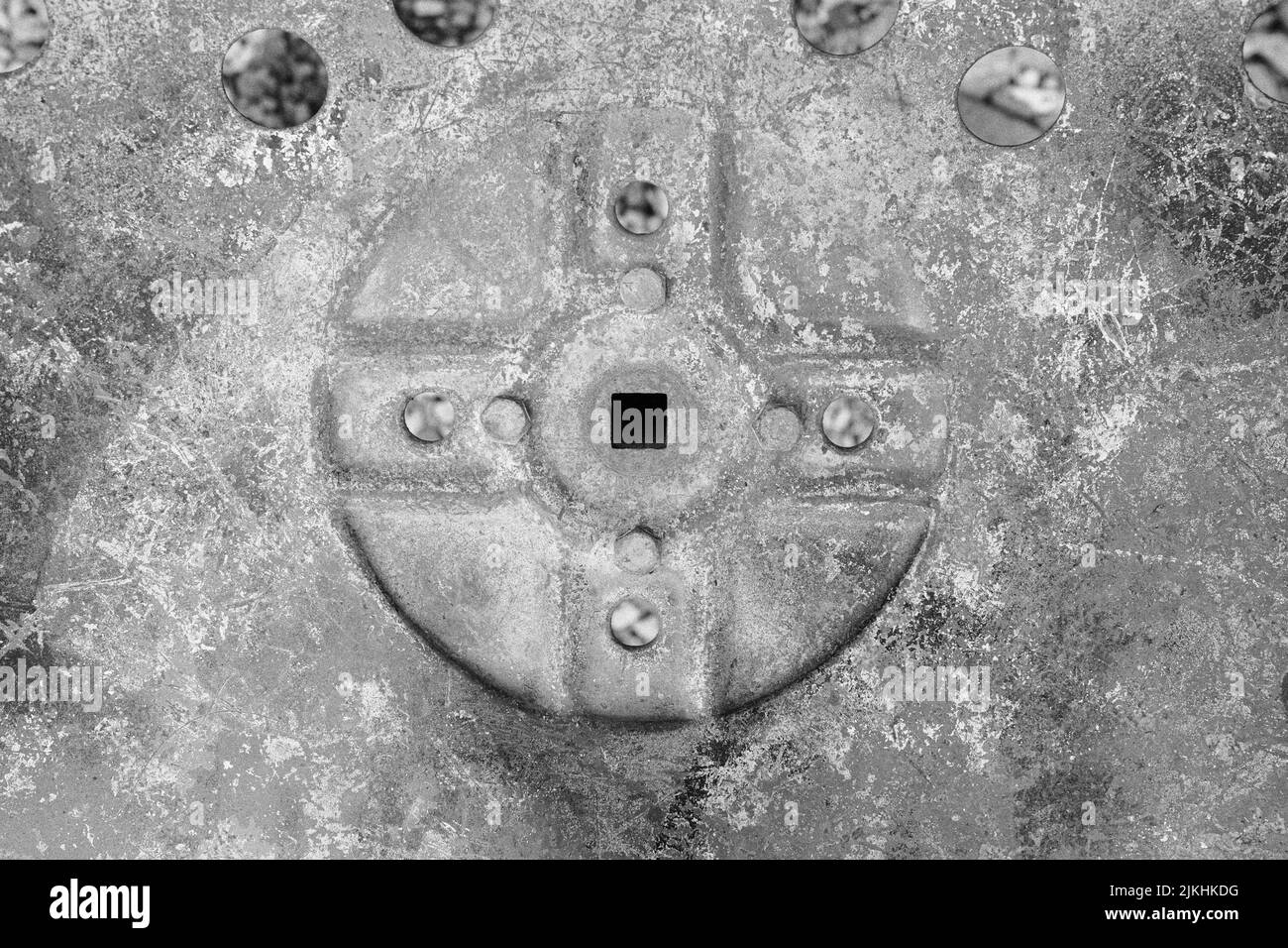 A top view of a metal plate in a circular shape with a black square ...