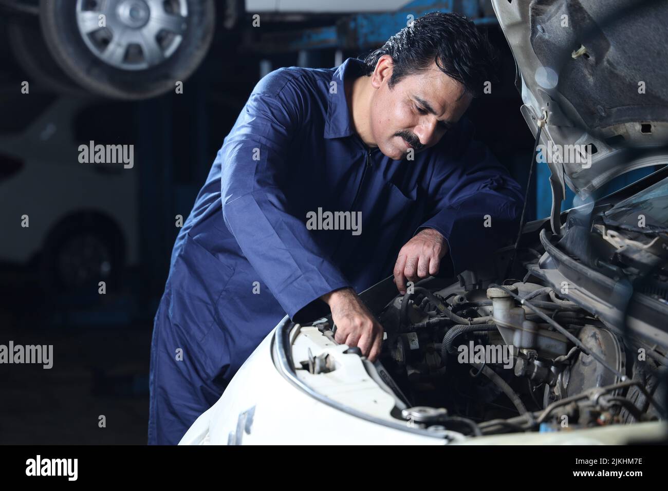 A mechanic working on a car in a garage Stock Photo - Alamy