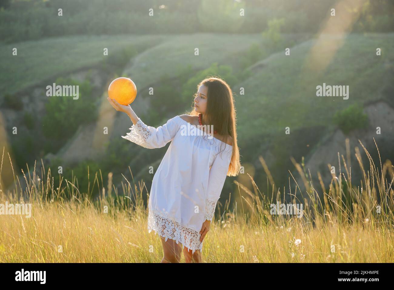 Teenage girl with a gymnastic ball on the background of a ravine ...