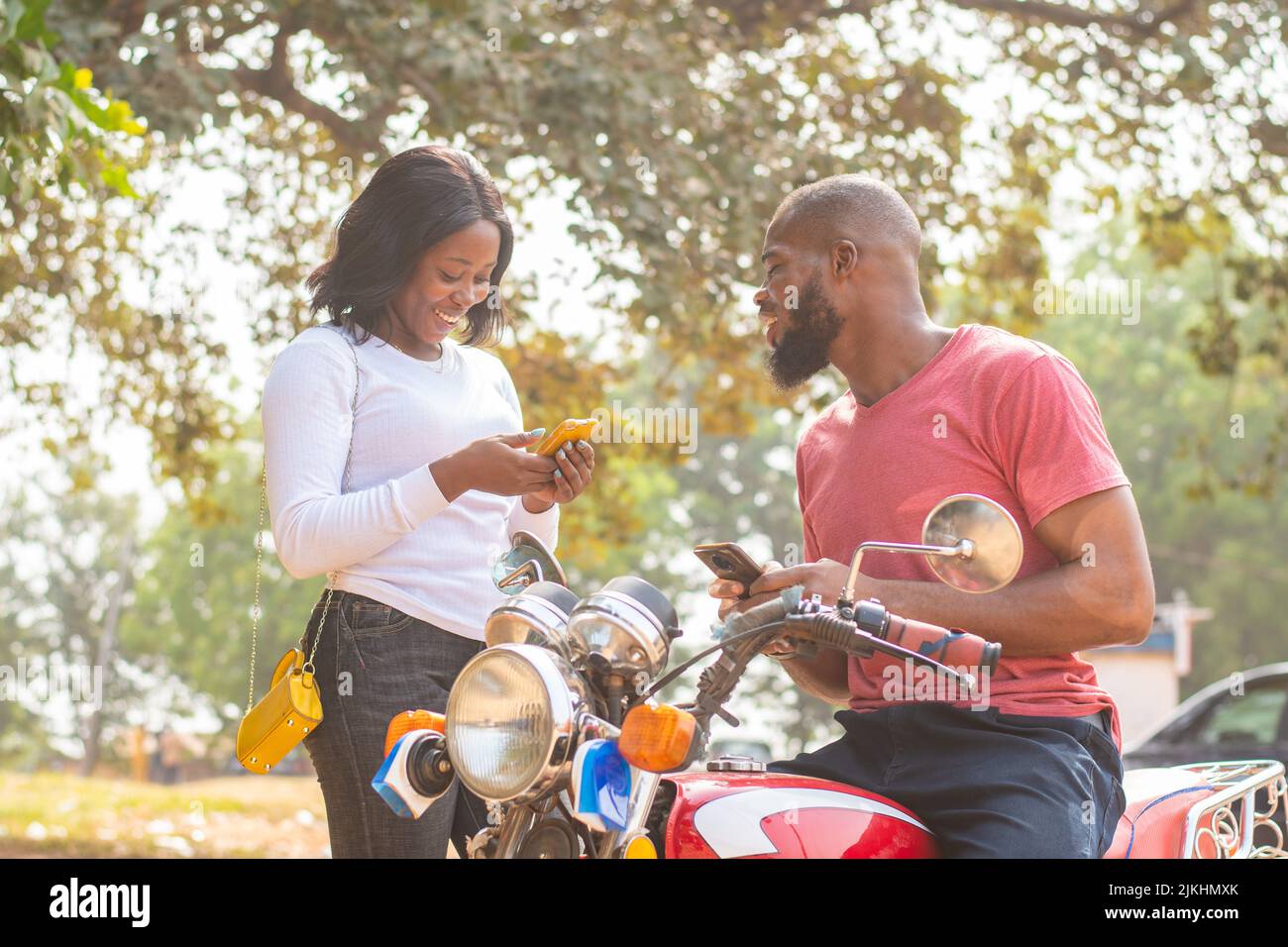 african man and woman sharing content from their phones Stock Photo - Alamy