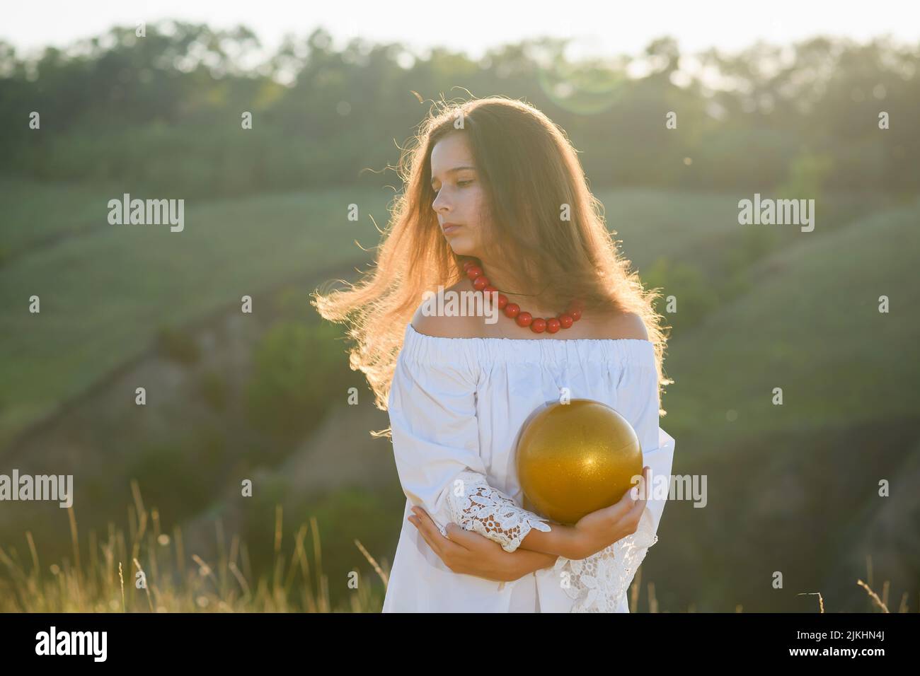 Teenage girl with a gymnastic ball on the background of a ravine ...