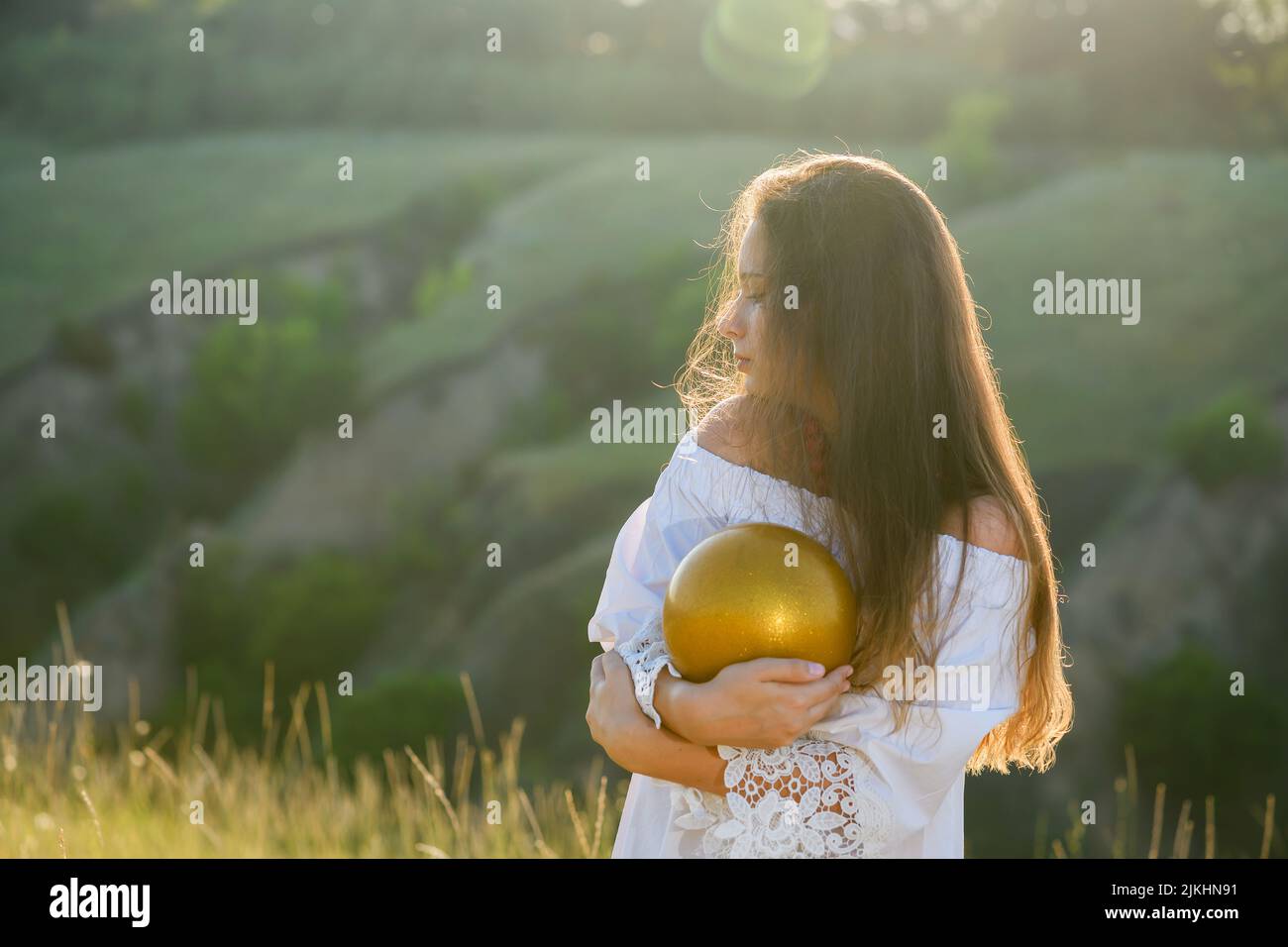 Teenage girl with a gymnastic ball on the background of a ravine ...