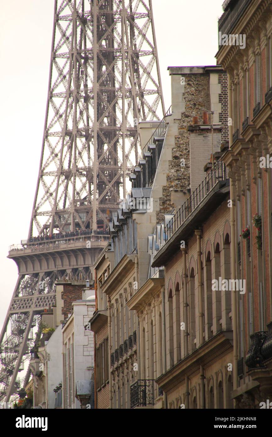 A vertical shot of the Eiffel tower part and buildings facades in Paris ...