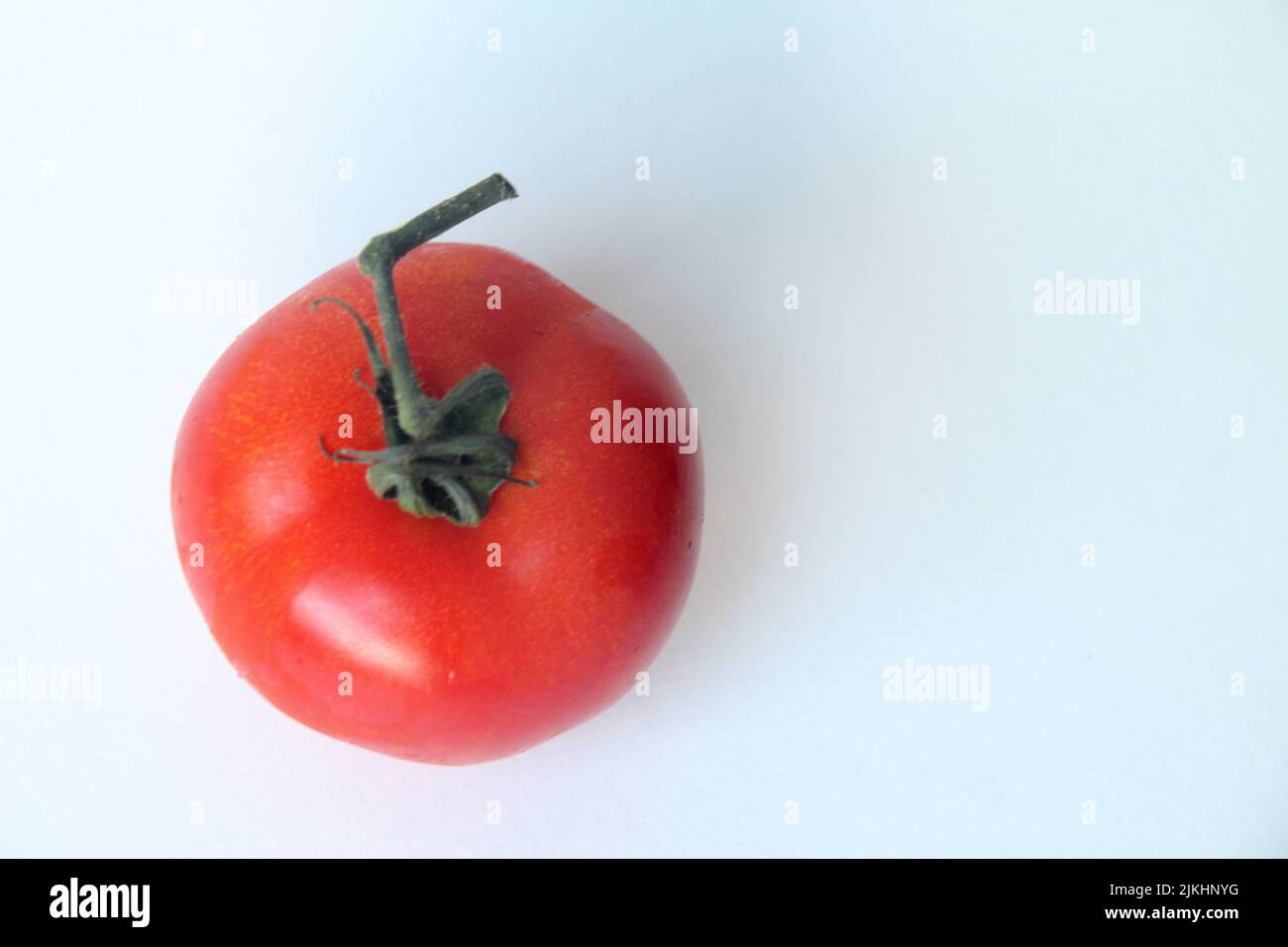 A fresh ripe tomato isolated on light background Stock Photo - Alamy