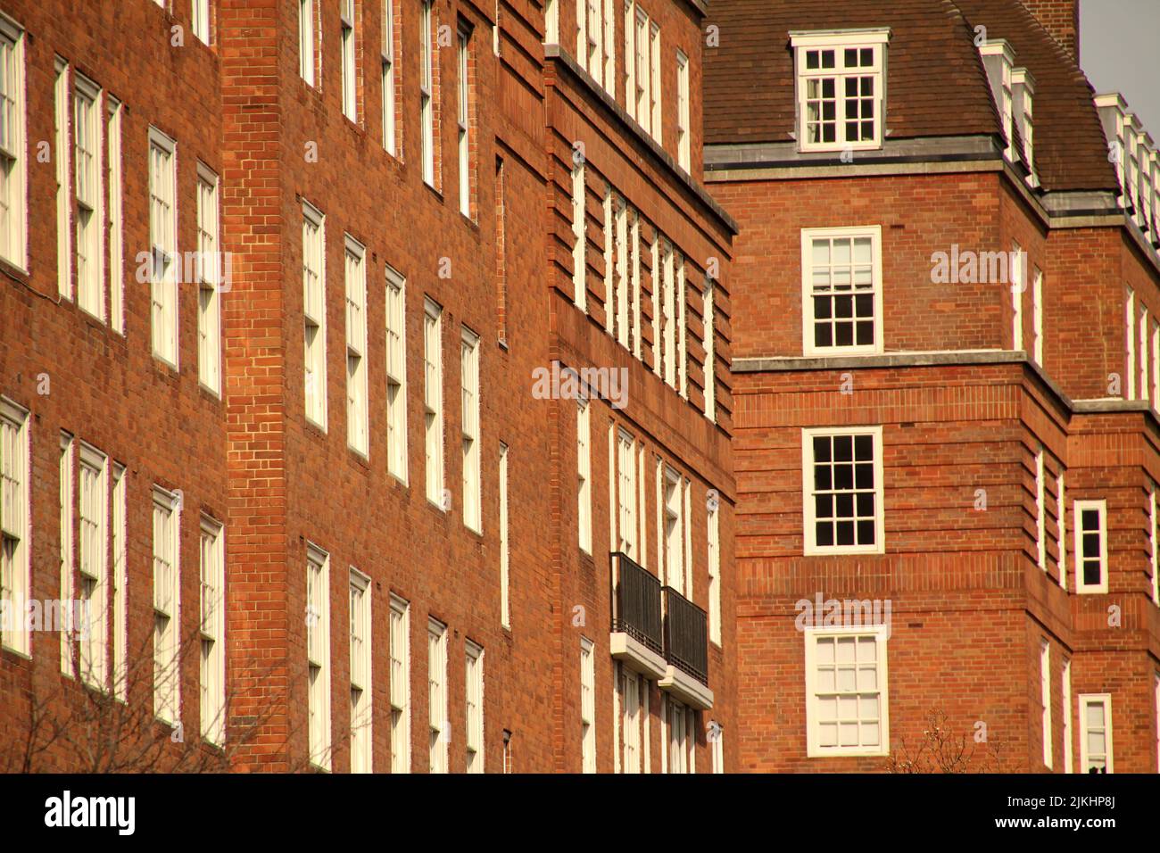 An orange brick building with white windows Stock Photo - Alamy