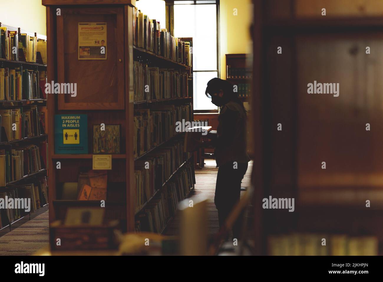 A shallow focus shot of a female checking out books in the library ...