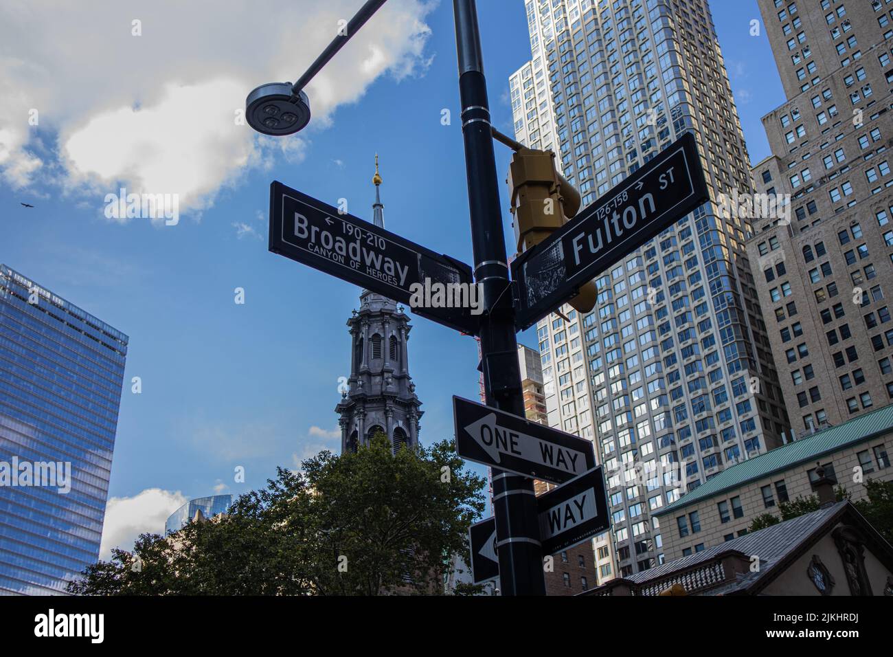 A bottom shot of a direction street signboard of Broadway and Fulton ...