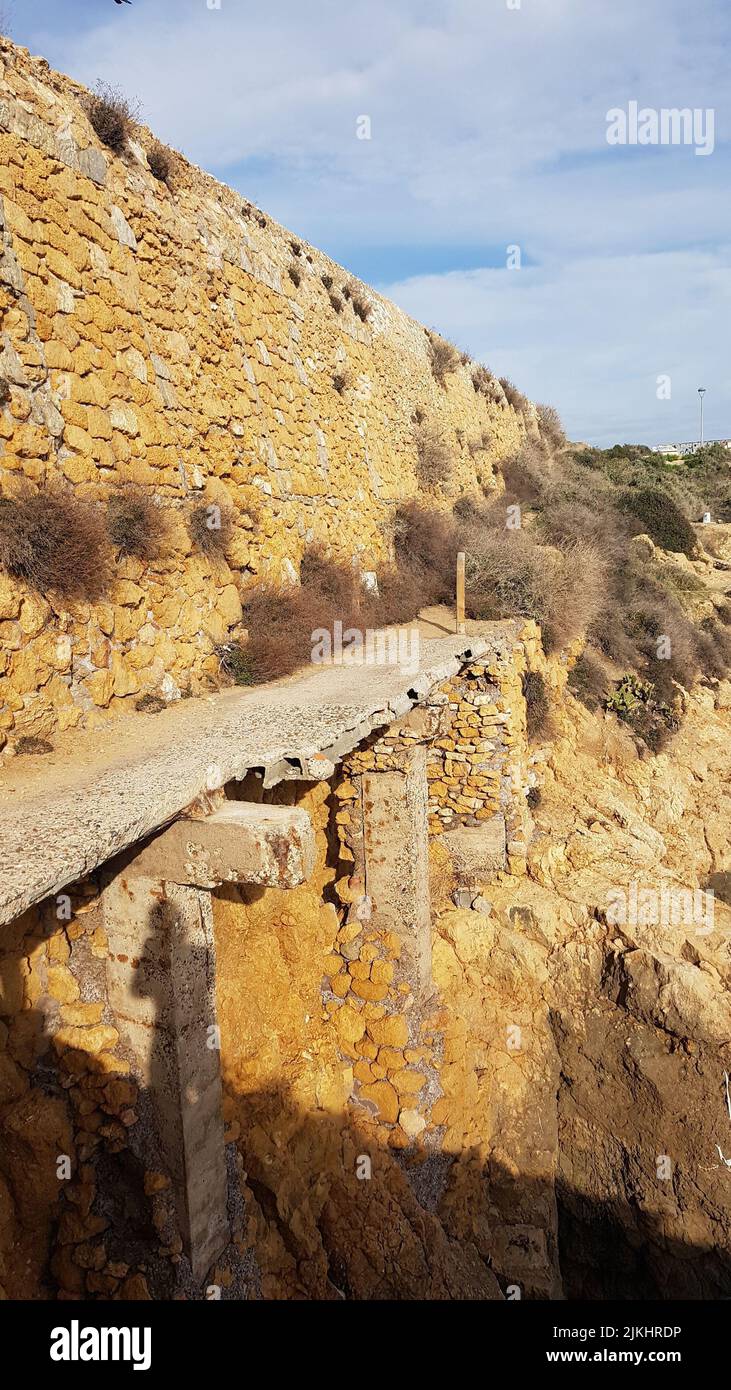 A vertical shot of a ruined path on a mountain on coastline off of ...