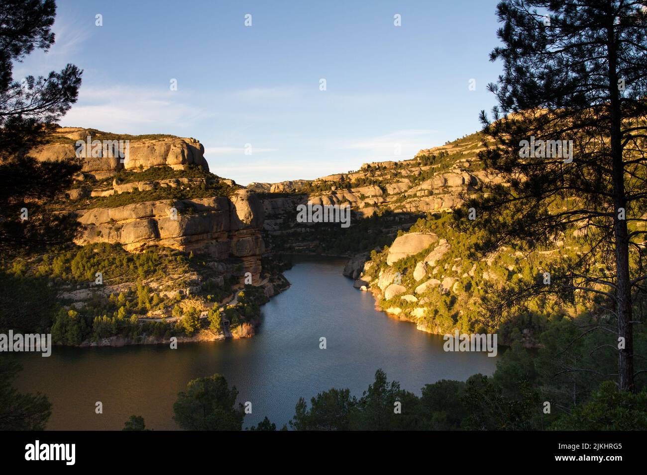 The sun rays on the cliffs surrounding the Panta de Margalef reservoir ...