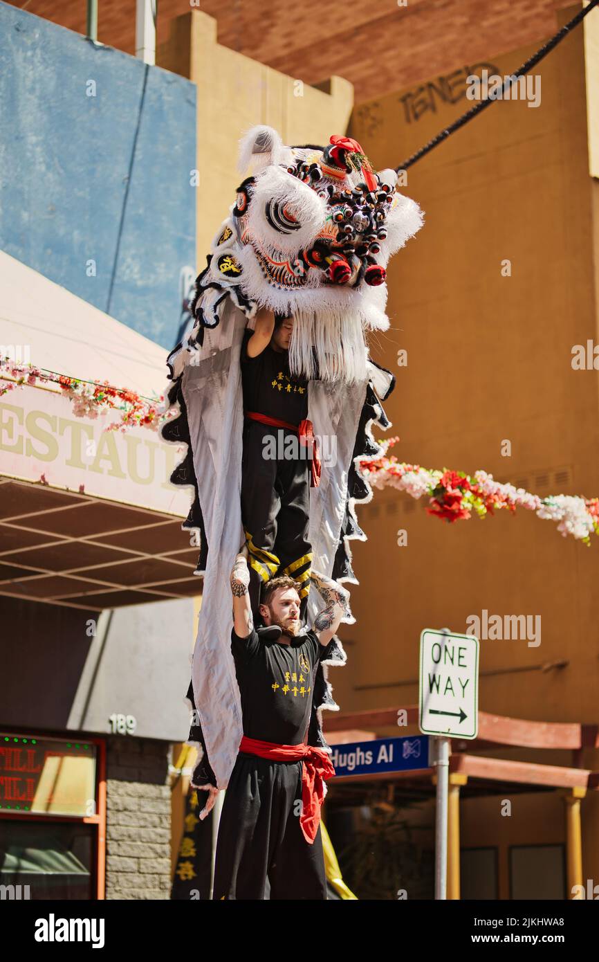 a vertical shot of dragon dancing in the middle of Chinatown in ...